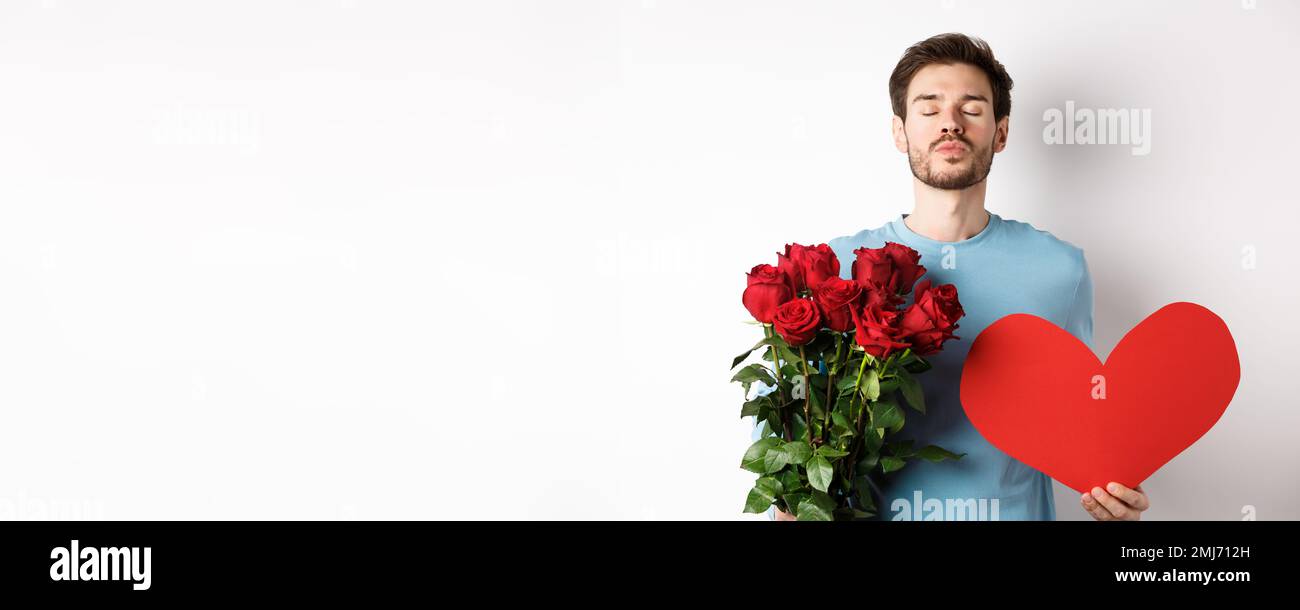 Romantic boyfriend waiting for kiss, holding bouquet of roses flowers ...