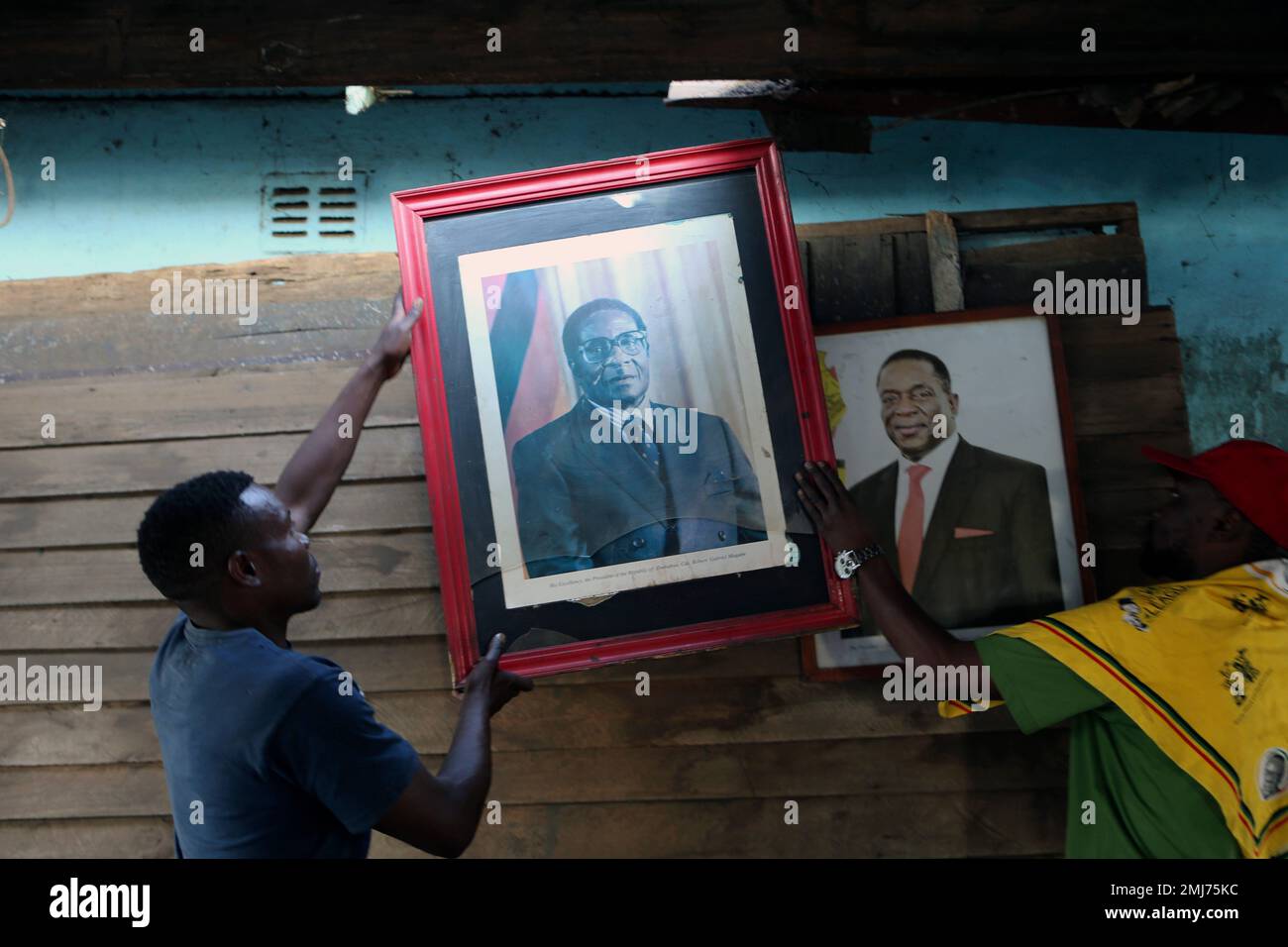 Supporters of Former Zimbabwean President Robert Mugabe place his portrait next to that of ...