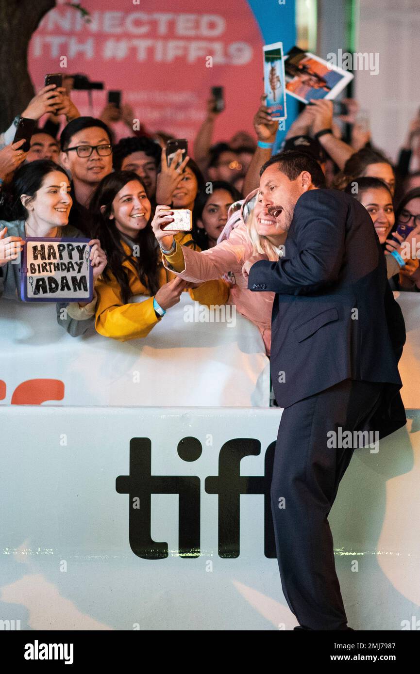 Actor Adam Sandler takes pictures with fans at a premiere for "Uncut ...