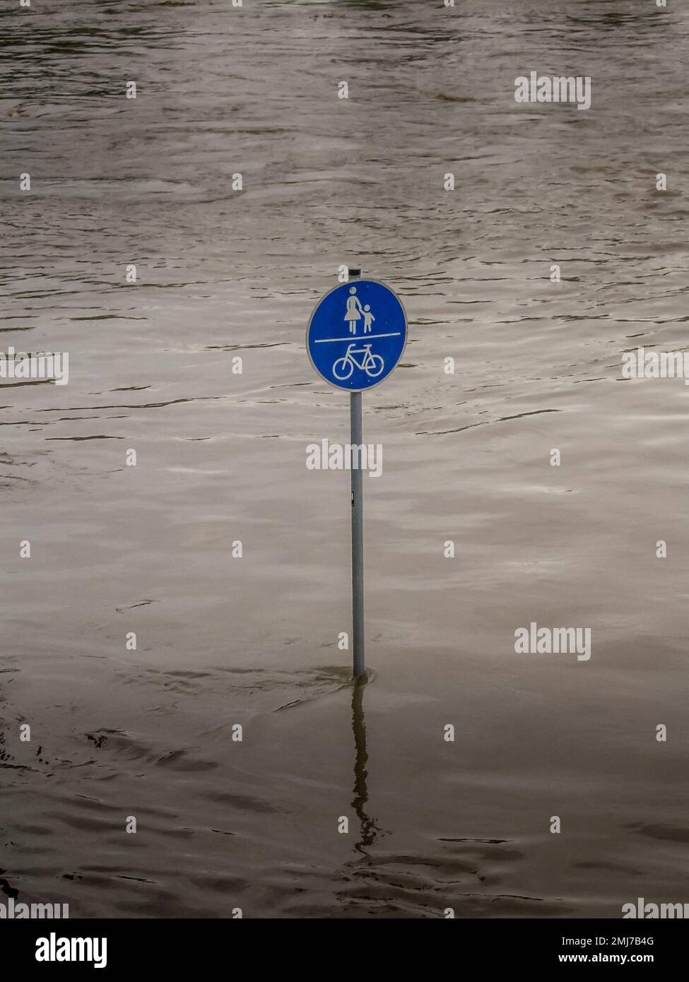Foot and bike path flooded during a flood. Only a traffic sign still ...
