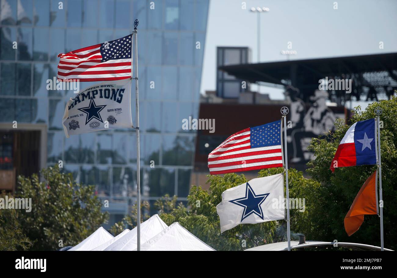 Flags fly over a tailgate area before a NFL football game between the ...