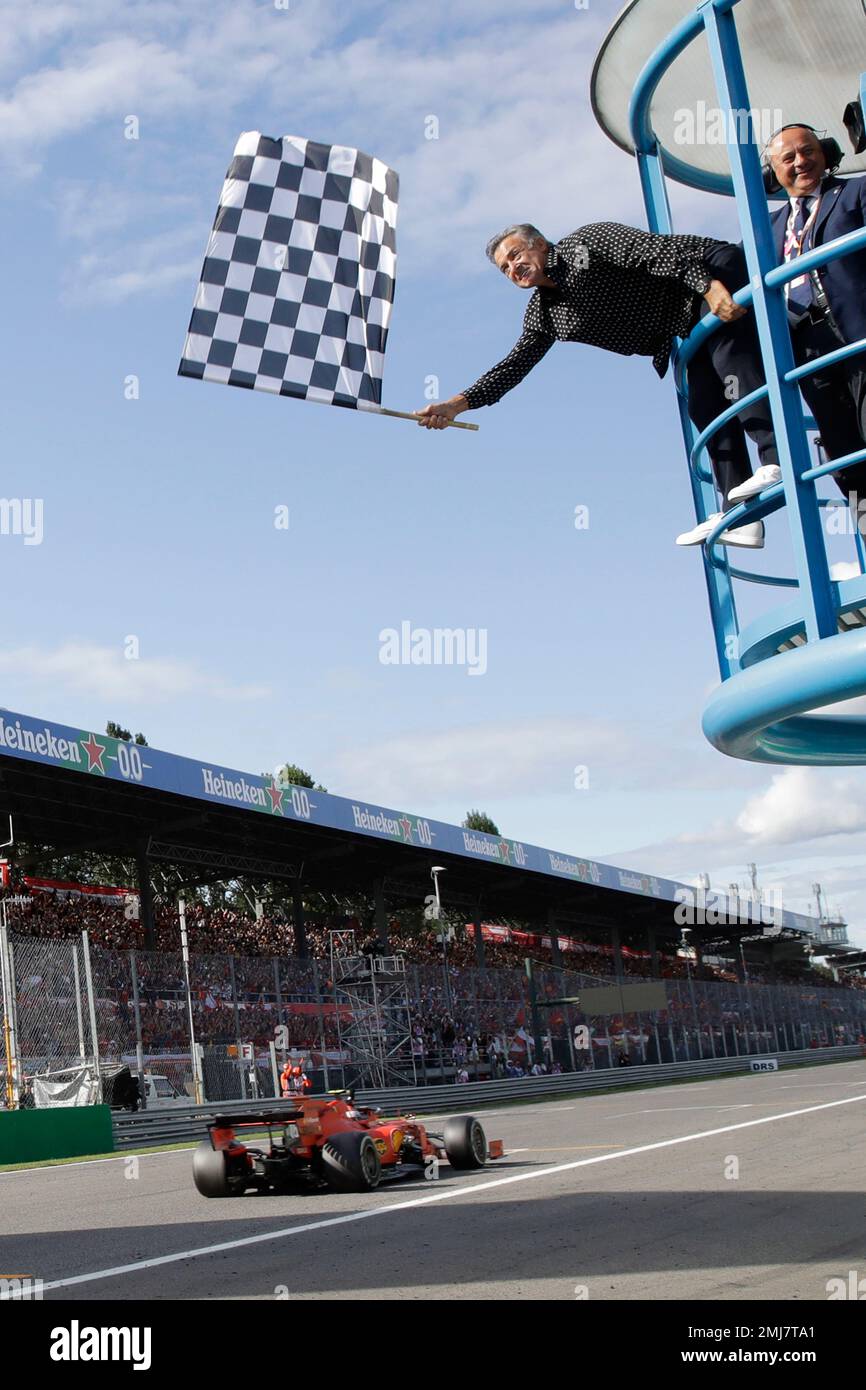 Former F1 driver Jean Alesi waves a checkered flag as Ferrari driver ...