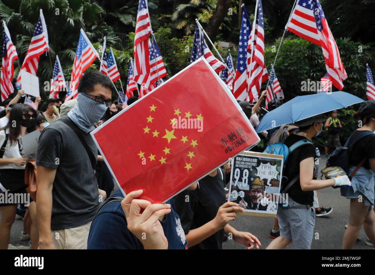 Protesters show posters of "Chinazi", a design of the Chinese flag ...
