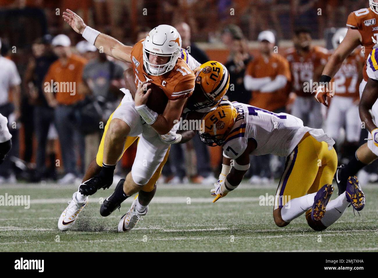 Texas quarterback Sam Ehlinger (11) is hit by LSU defensive end Justin ...