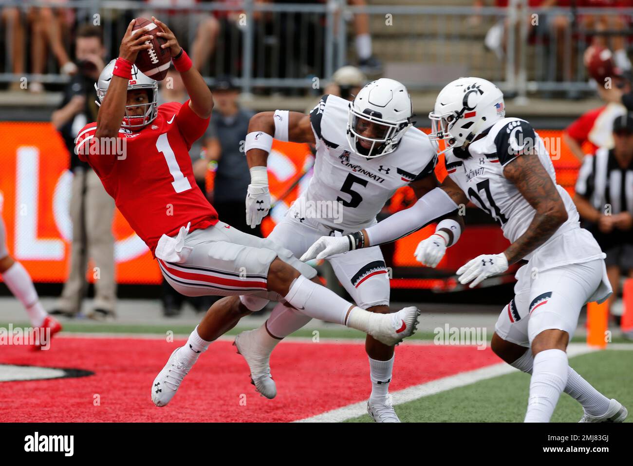 Ohio State quarterback Justin Fields, left, dives over the goal line ...