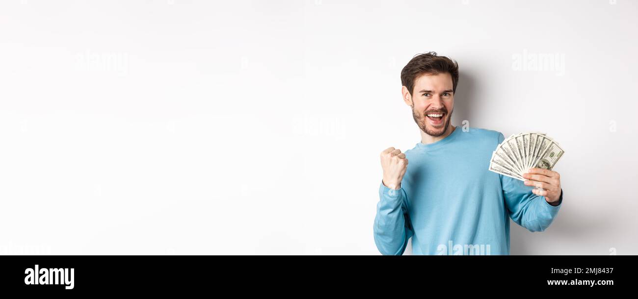 Happy man dancing with money, showing dollars and saying yes with ...