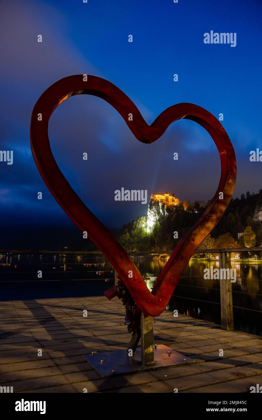 Heart symbol at jetty at lake bled with a view on the island and rowing ...