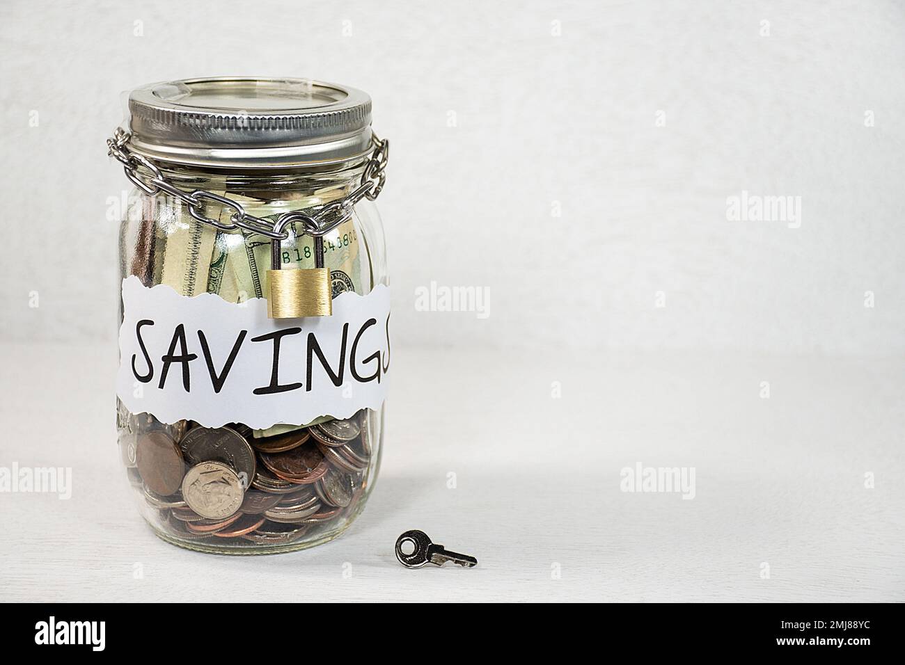 Savings label on Mason jar filled with American currency wrapped with ...