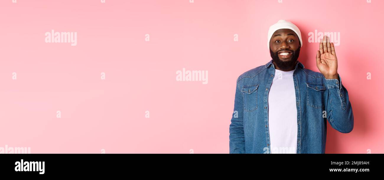 Friendly smiling Black man saying hello, waving hand, greeting you ...