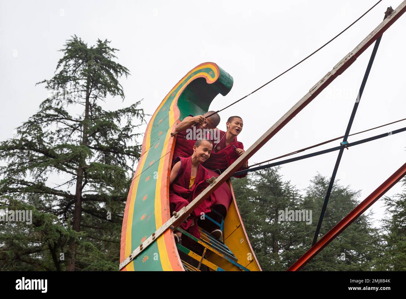 Novice Buddhist monks react as they ride a pendulum swing at a local ...