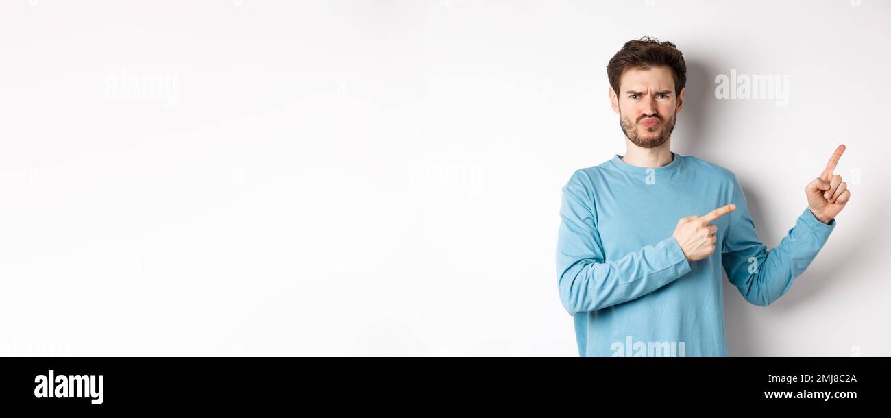 Disappointed and upset young man showing bad offer, pointing fingers ...