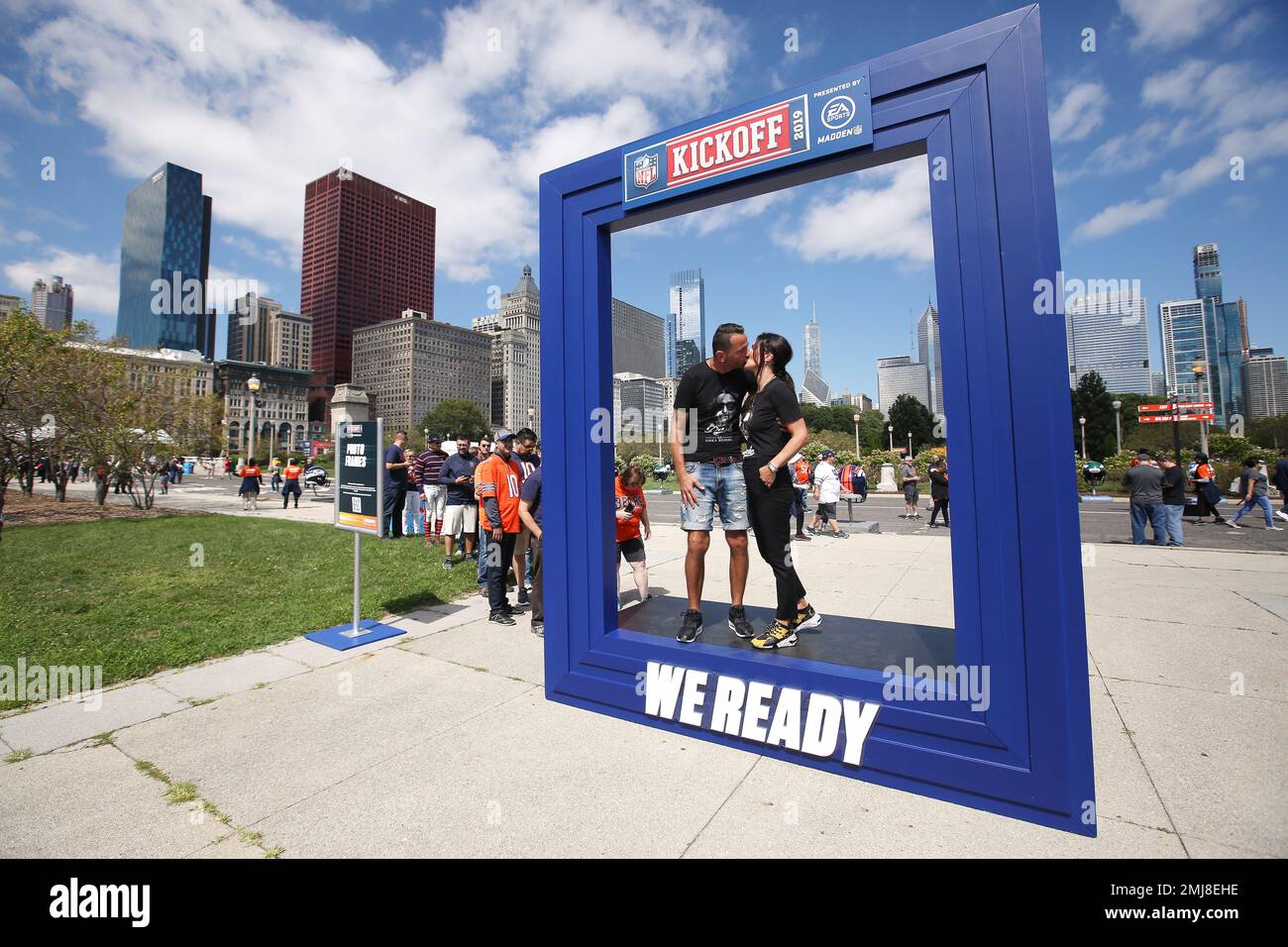 A couple of fans kiss at a photo booth during the NFL Experience on ...
