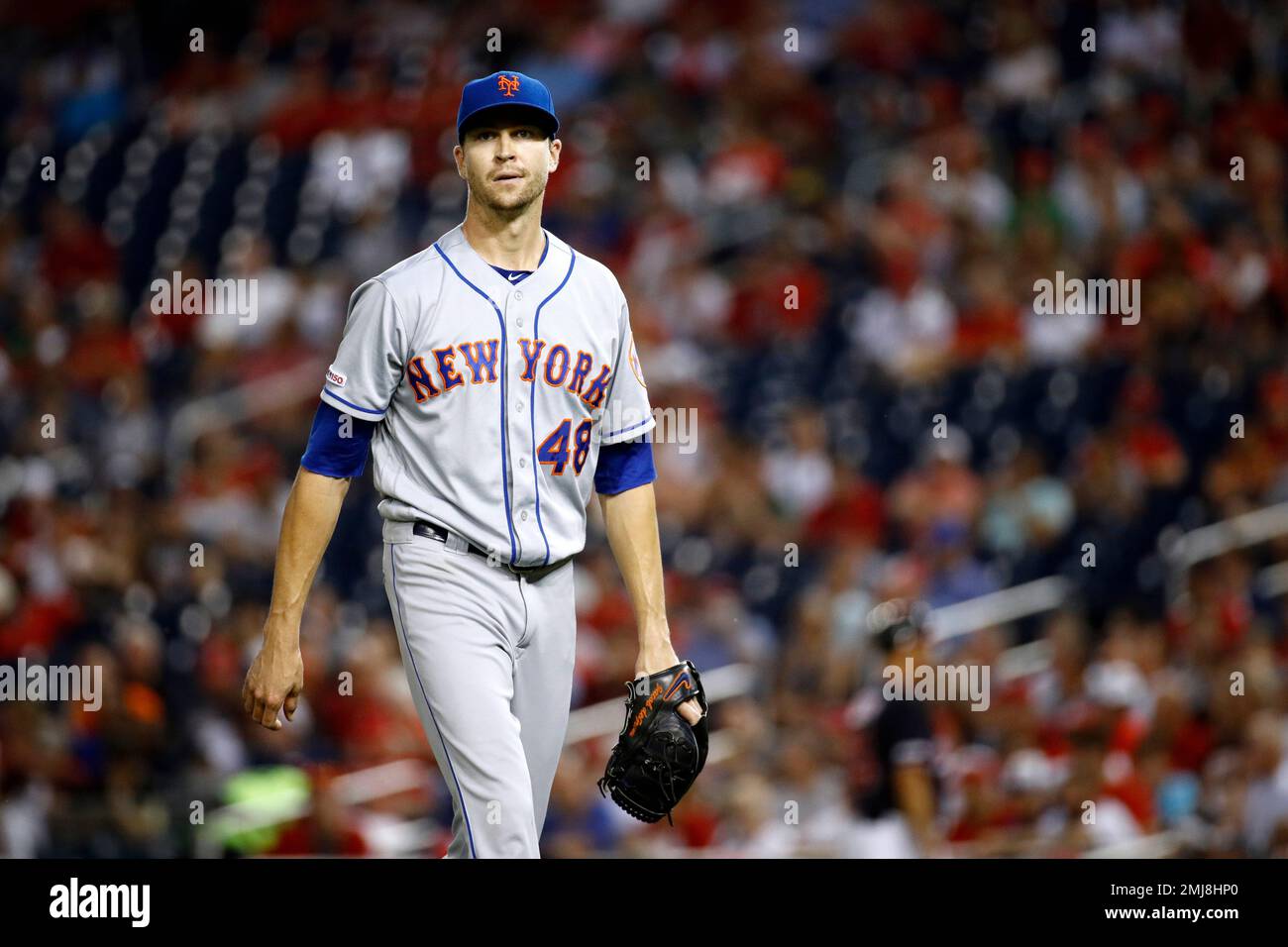 New York Mets starting pitcher Jacob deGrom walks off the field between ...