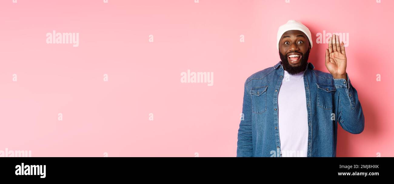 Friendly smiling Black man saying hello, waving hand, greeting you ...