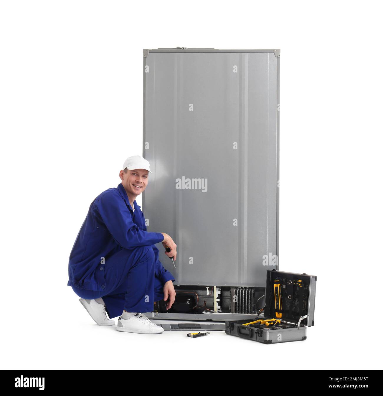 Male technician repairing refrigerator on white background Stock Photo ...