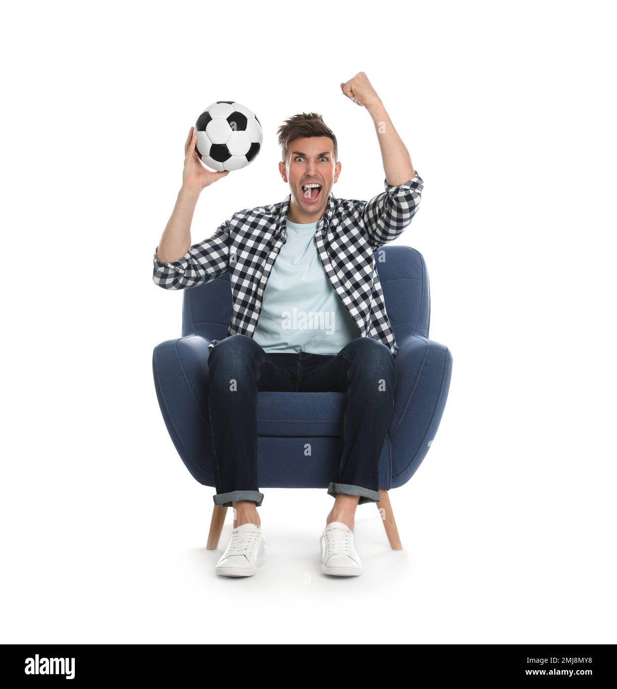 Handsome young man sitting in armchair and watching soccer match on ...