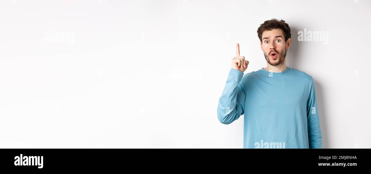 Image of excited handsome man pitching an idea, raising finger and ...