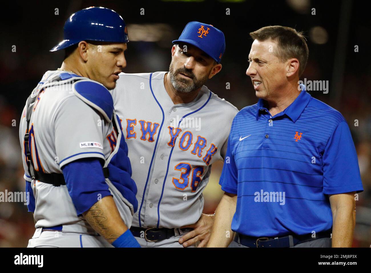 New York Mets manager Mickey Callaway, center, and a member of the Mets ...