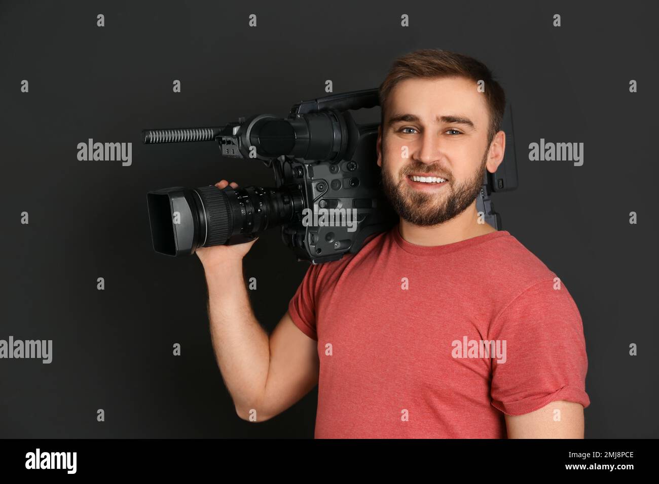 Operator with professional video camera on black background Stock Photo ...