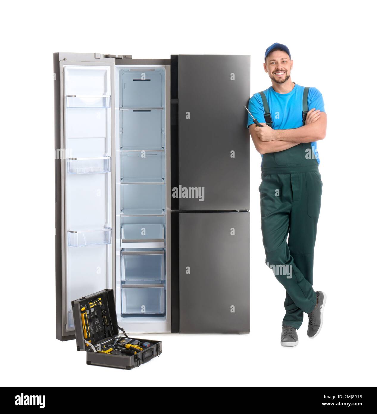 Male technician with tool box near refrigerator on white background ...