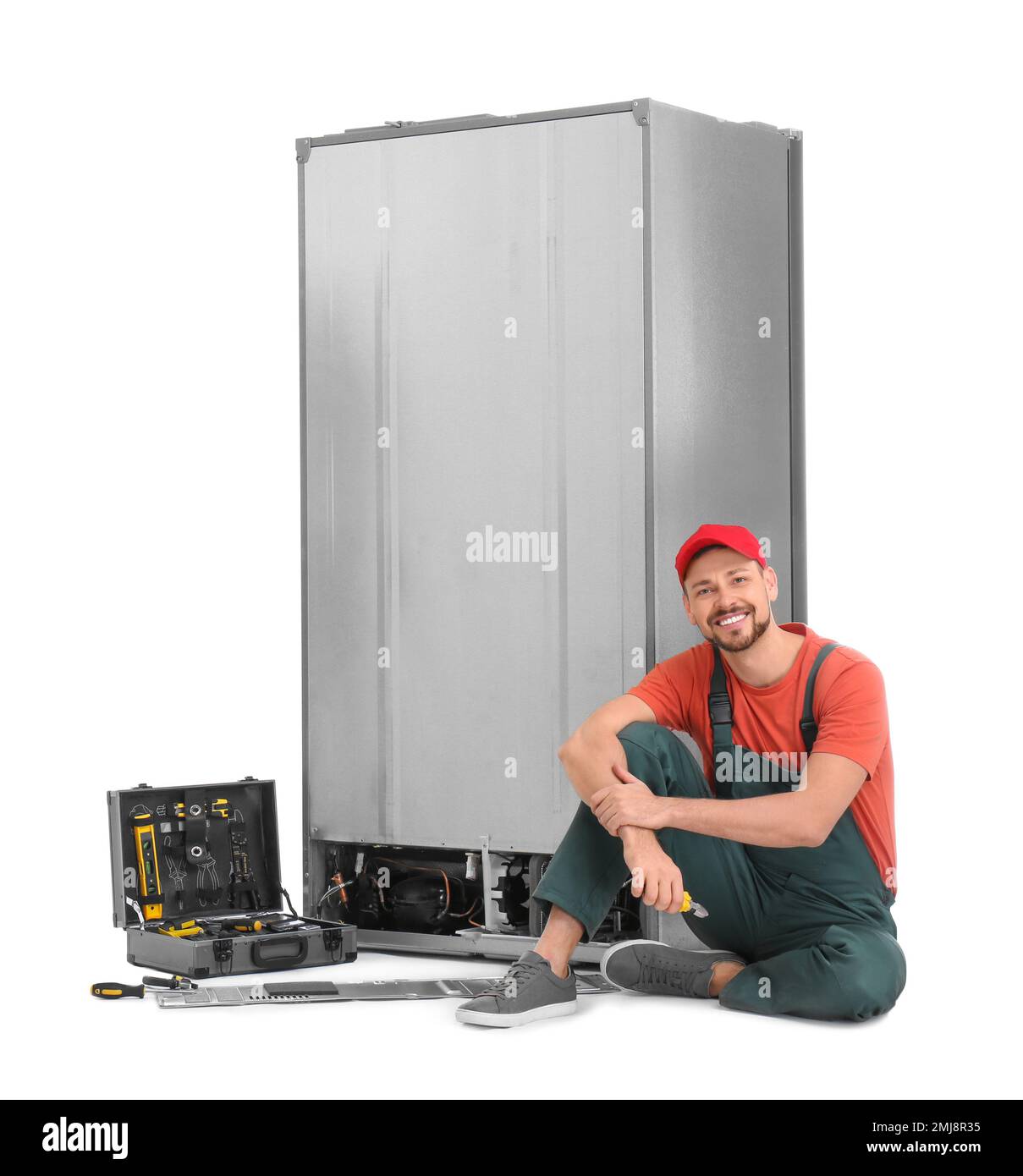 Male technician repairing refrigerator on white background Stock Photo ...