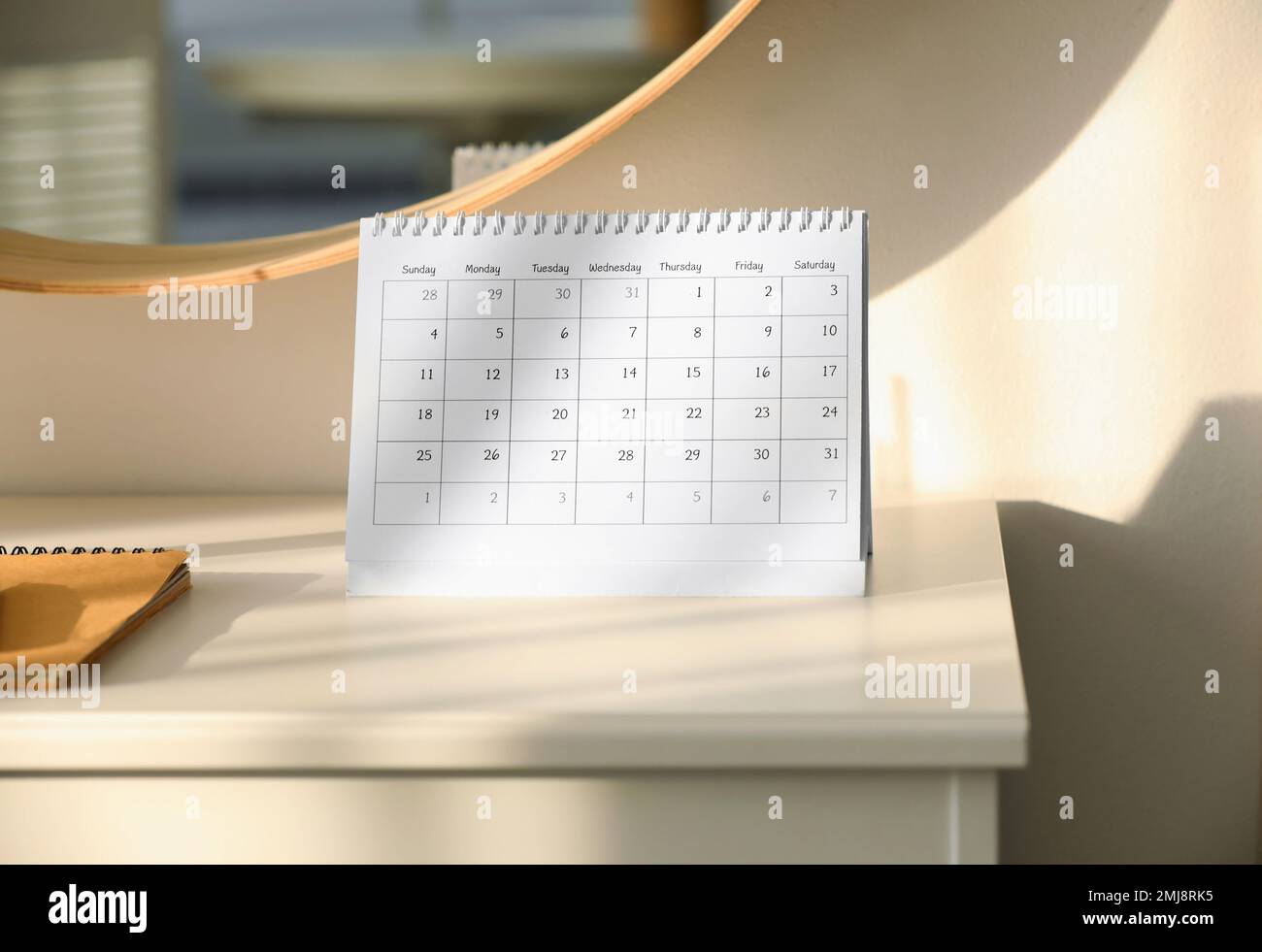 Paper calendar on white chest of drawers indoors Stock Photo - Alamy