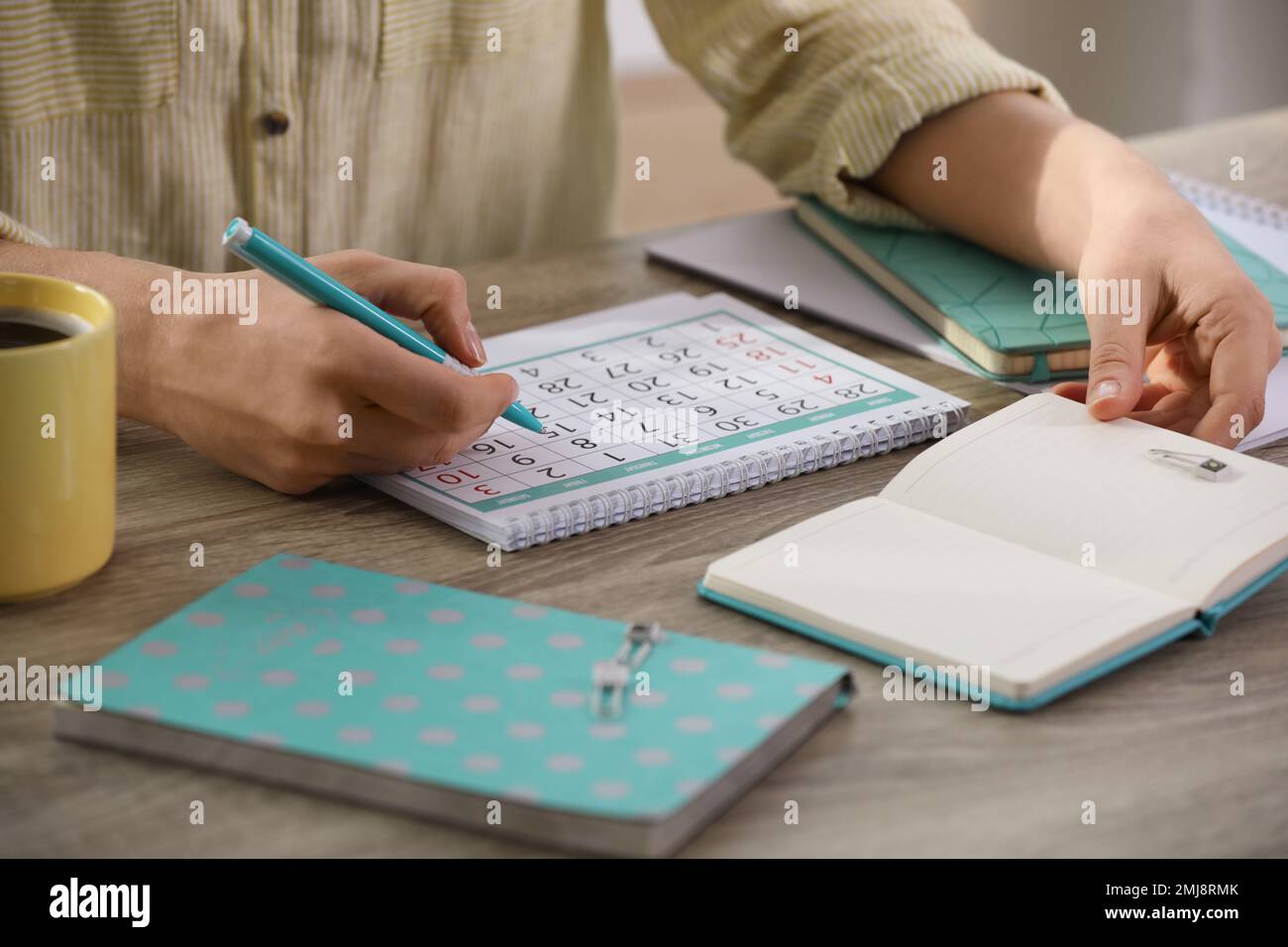 Woman making schedule using calendar at wooden table, closeup Stock ...