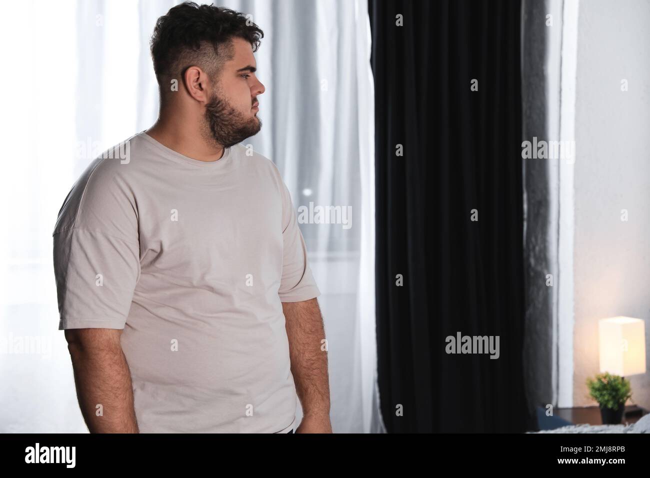 Overweight man suffering from depression at home Stock Photo - Alamy