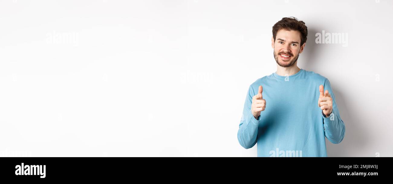 Well done. Smiling handsome man pointing fingers at camera to ...