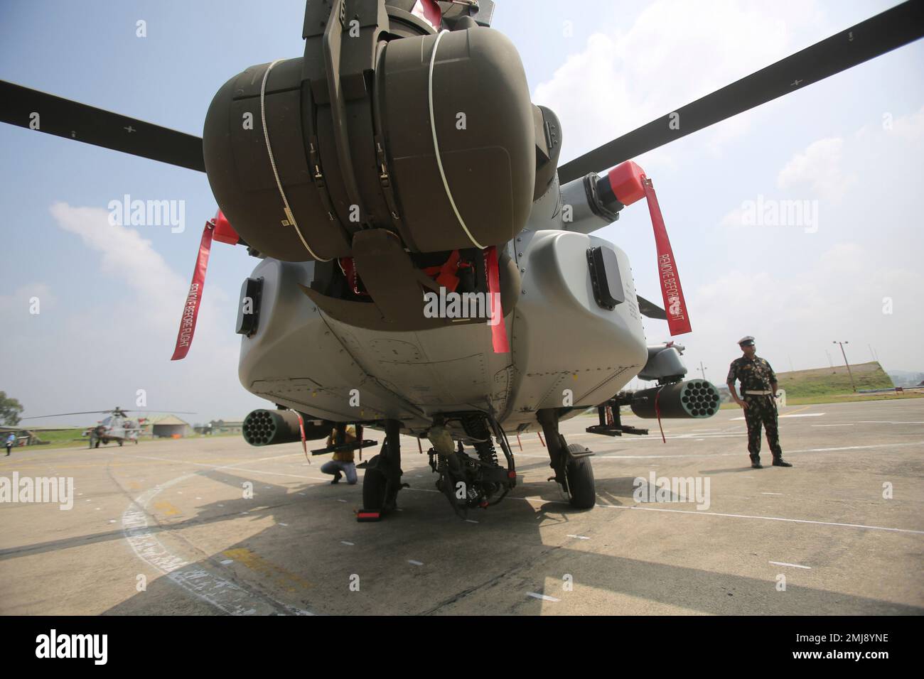 An Indian Air Force soldier stands near a AH-64E Apache helicopter ...