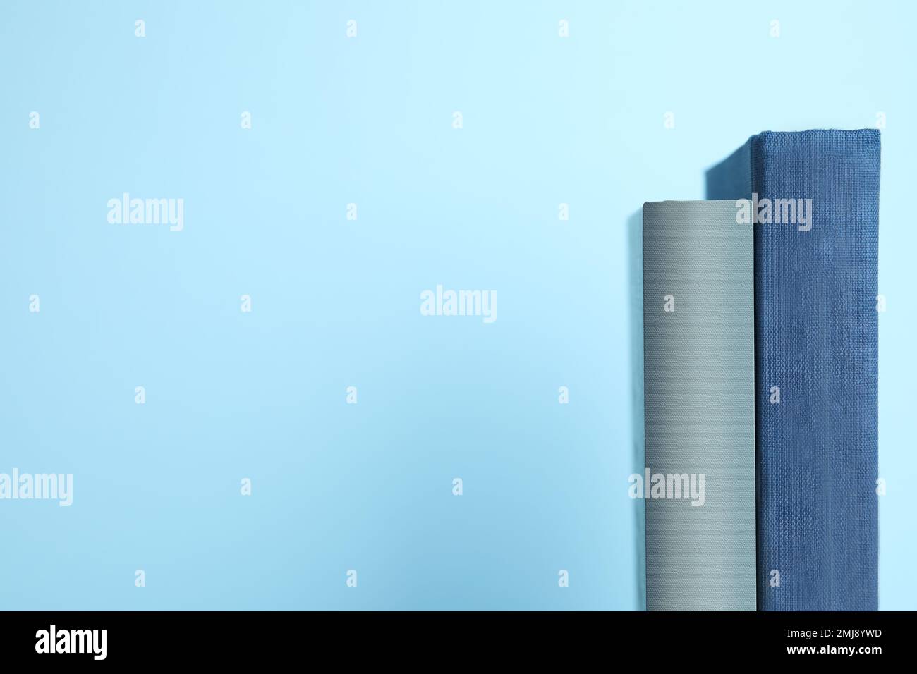 Old books on light blue background, space for text Stock Photo - Alamy