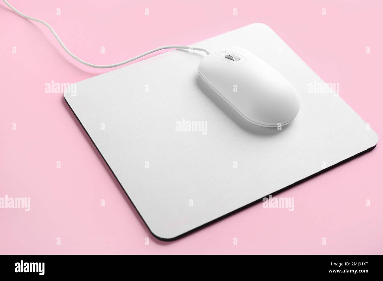 Modern wired optical mouse and pad on pink background Stock Photo - Alamy