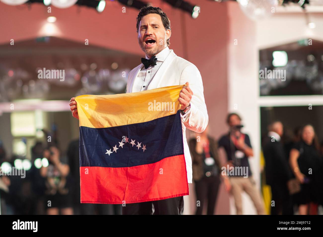Actor Edgar Ramirez holds a Venezuelan flag as he poses for ...