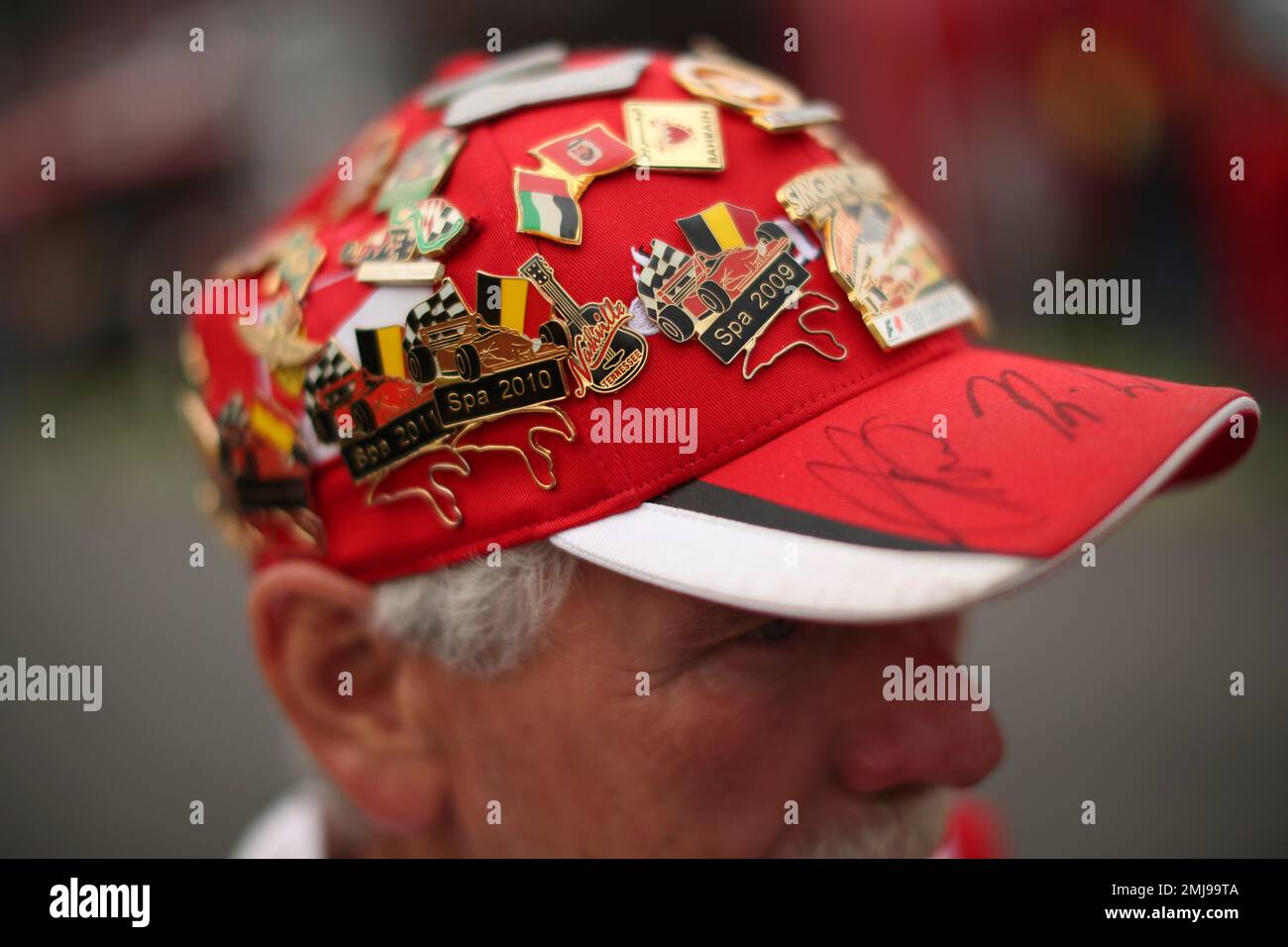 A fan wears a cap with Formula One pins in the fan zone at the Belgian ...