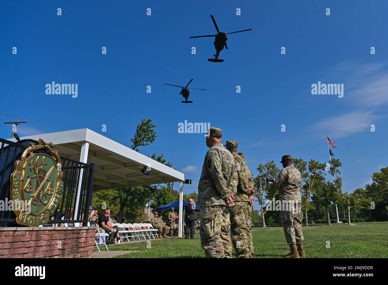 Two UH-60 Blackhawk helicopters fly above a change of command ceremony ...