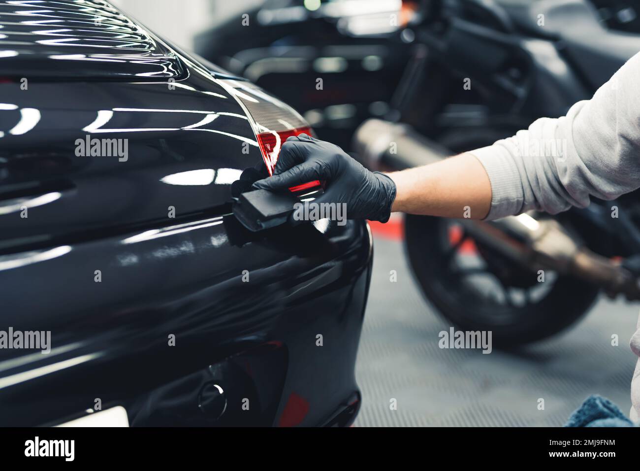 Close-up shot of unrecognisable man wearing black gloves applying ...
