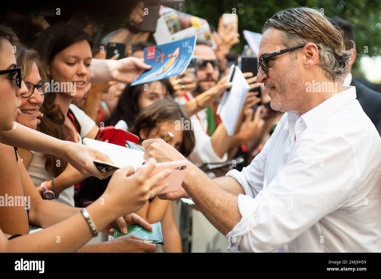 Actor Joaquin Phoenix signs autographs upon arrival for the photo call ...