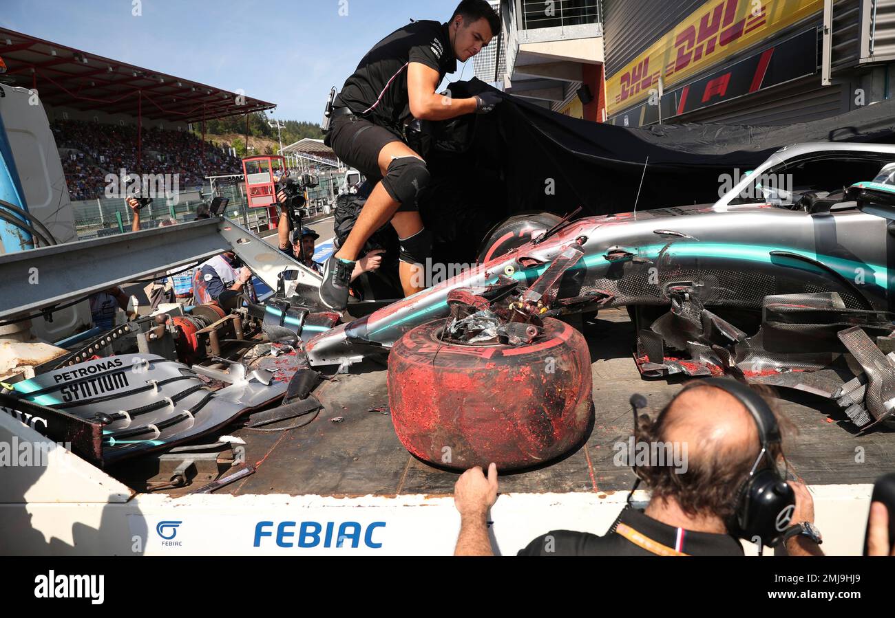 Pit crew inspect the damaged car of Mercedes driver Lewis Hamilton of ...