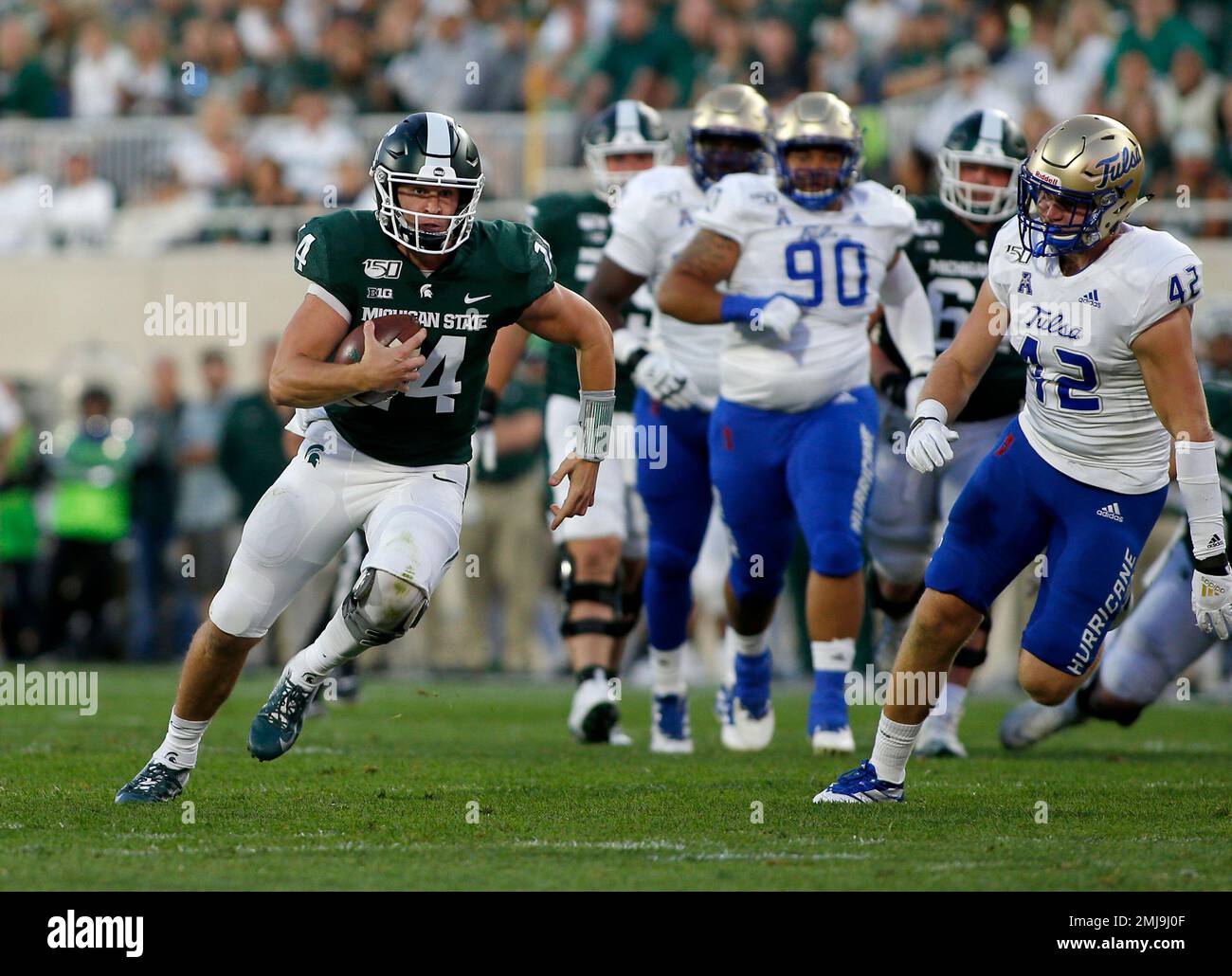 Michigan State quarterback Brian Lewerke, left, runs for a first down ...
