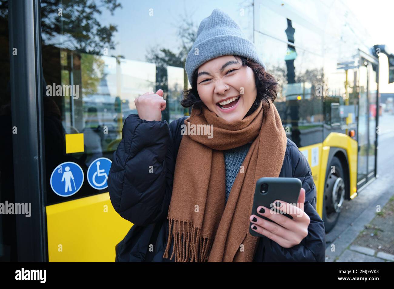 Enthusiastic girl rejoice, reads message on mobile phone and celebrates ...