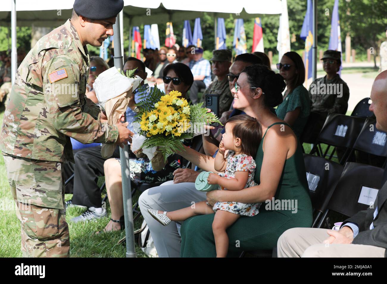U.S. Army Cpl. Mendez presents a bouquet of yellow rose buds to ...