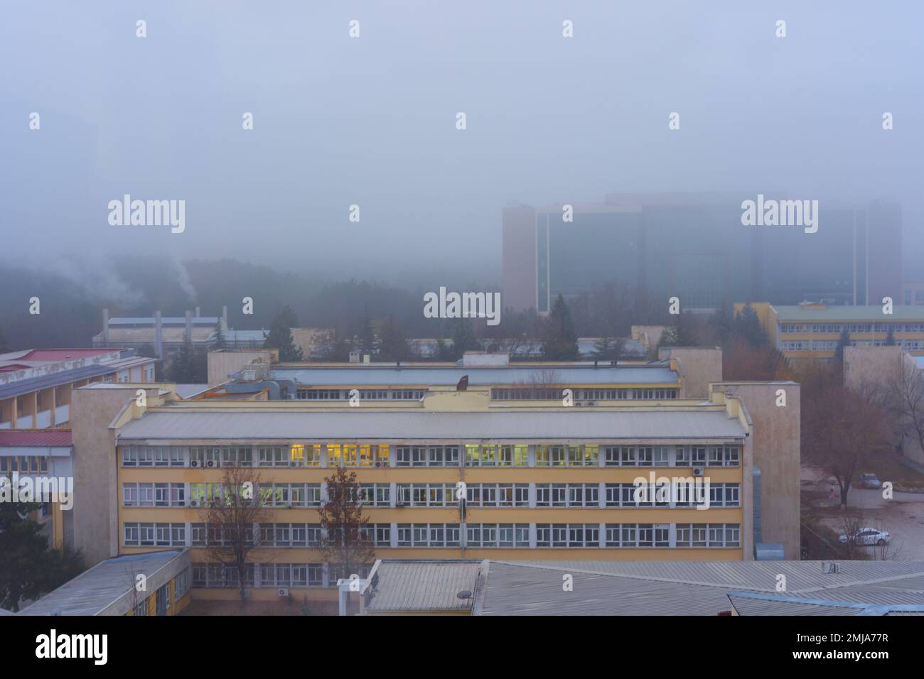 High angle view of sunset on large buildings over hills in early ...