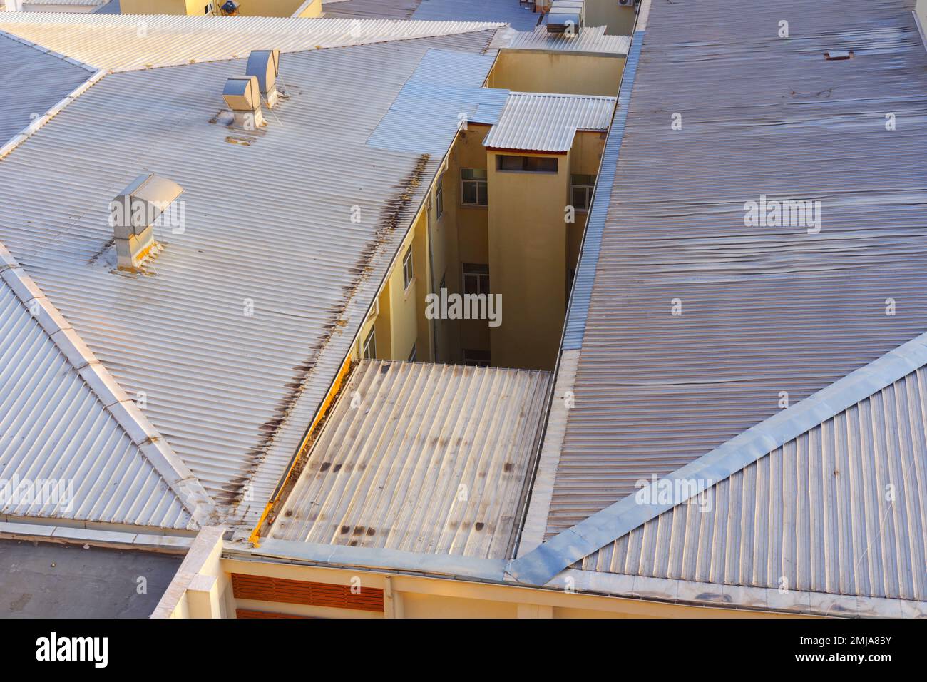 Metal rooftop of large buildings from the top at sunrise Stock Photo ...