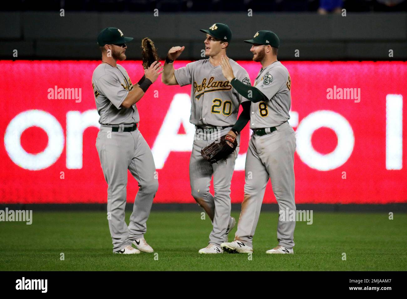Oakland Athletics outfielders Chris Herrmann, left, Mark Canha (20) and ...