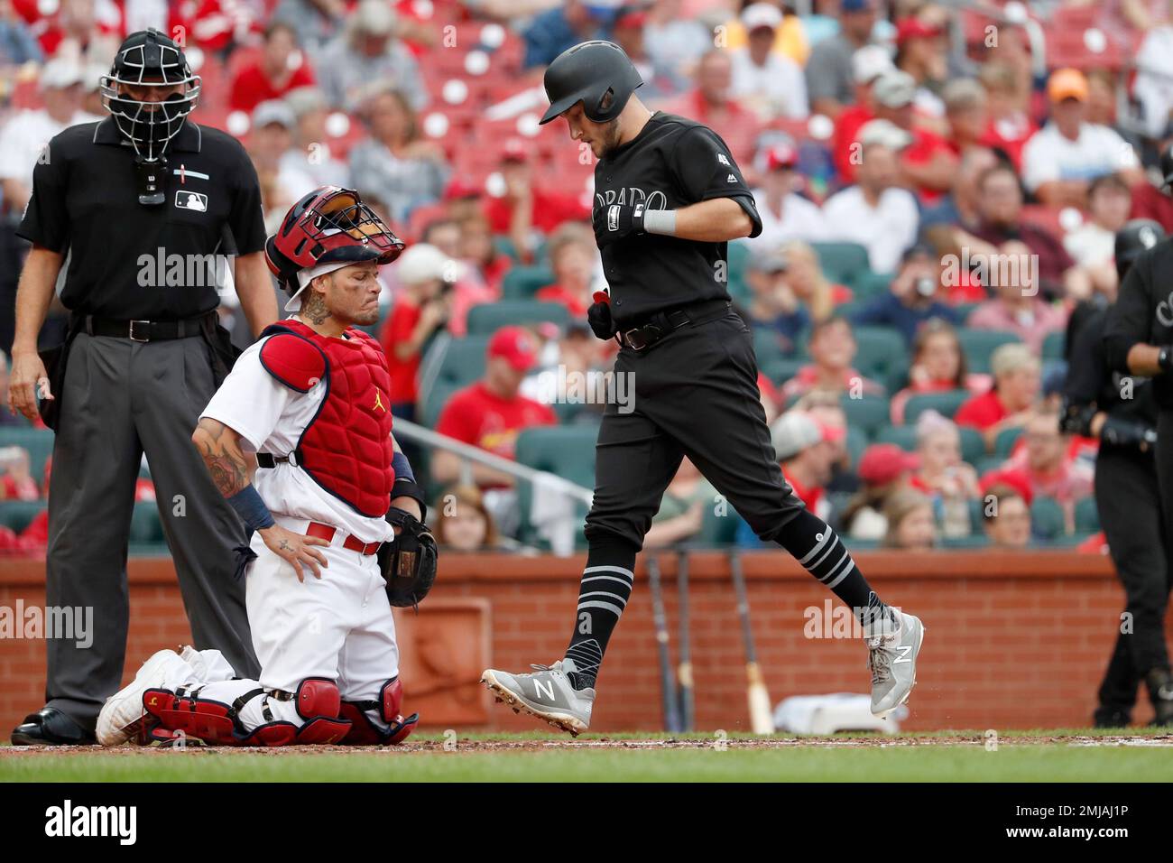 Colorado Rockies' Garrett Hampson, right, arrives home after hitting a ...