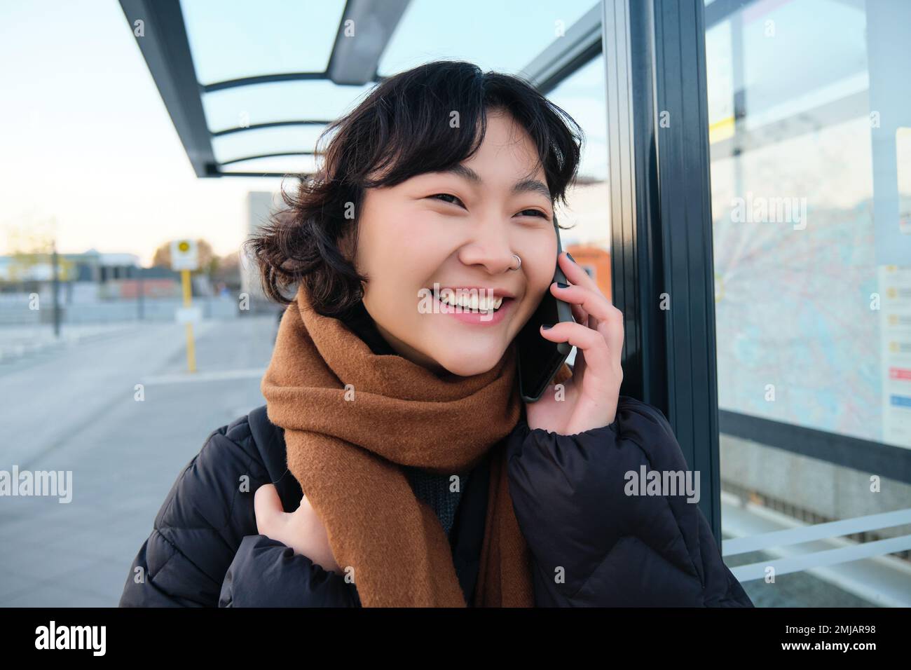 Close up of cute Korean woman, making a phone call, talking and smiling ...