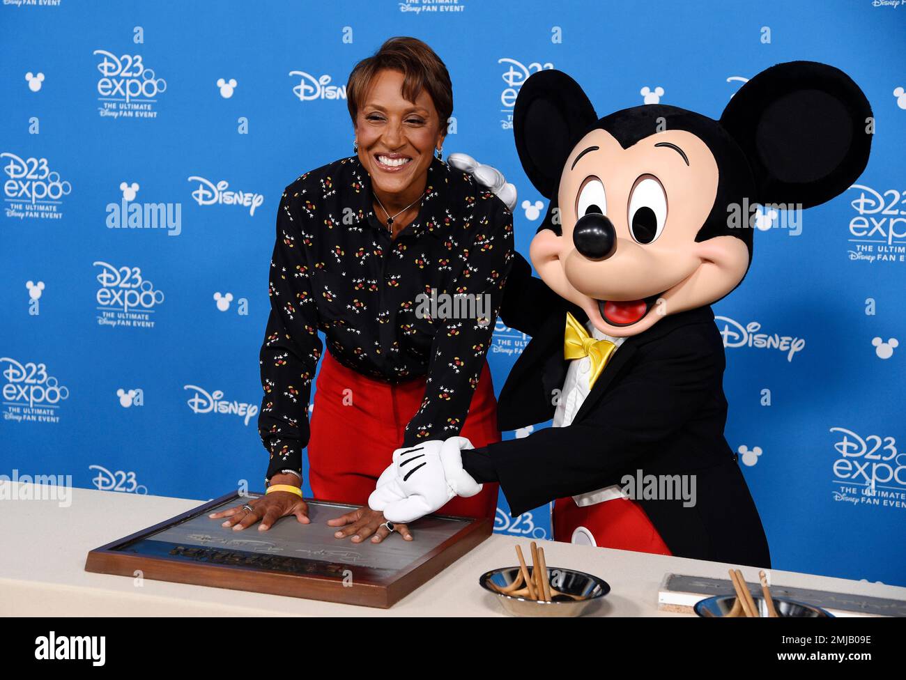 Television journalist Robin Roberts poses with Mickey Mouse during her ...