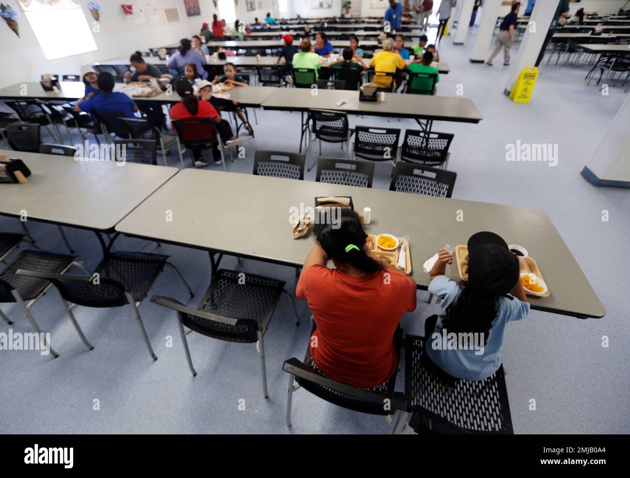 Immigrants seeking asylum eat in a cafeteria at the ICE South Texas ...