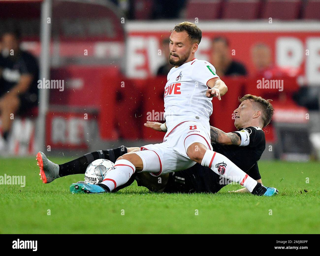 Cologne's Birger Verstraete, left, is tackled by Dortmund's Marco Reus ...