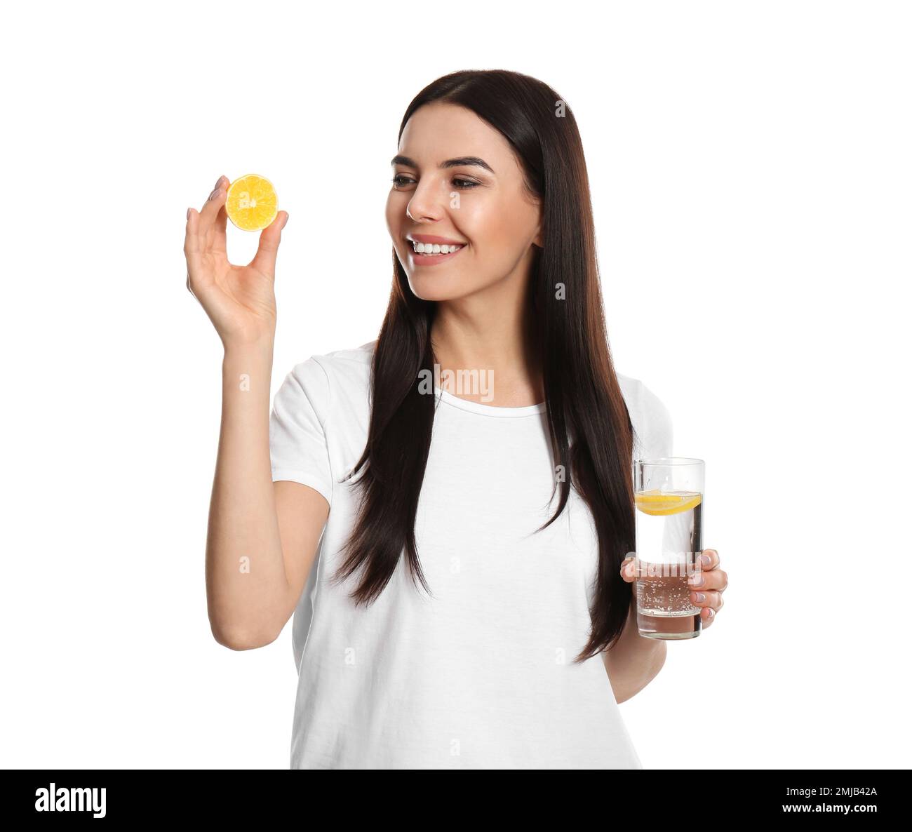 Beautiful young woman with tasty lemon water and fresh fruit on white ...